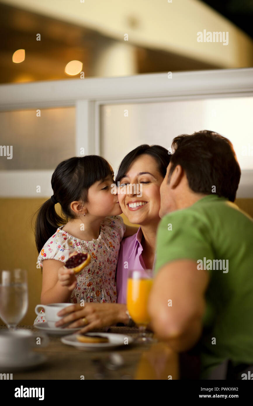 Affectionate family eating breakfast together at a cafe Stock Photo - Alamy