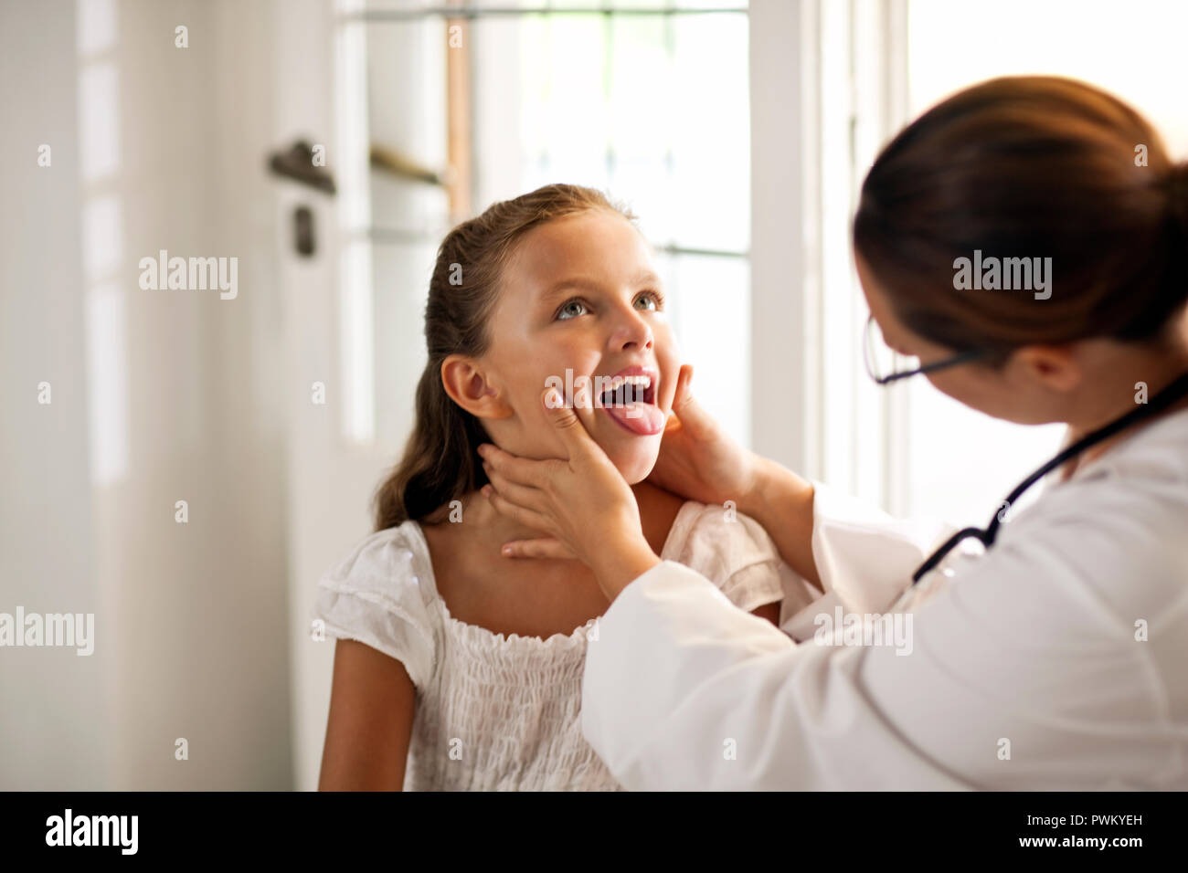 Friendly gentle female doctor examining young patient Stock Photo - Alamy