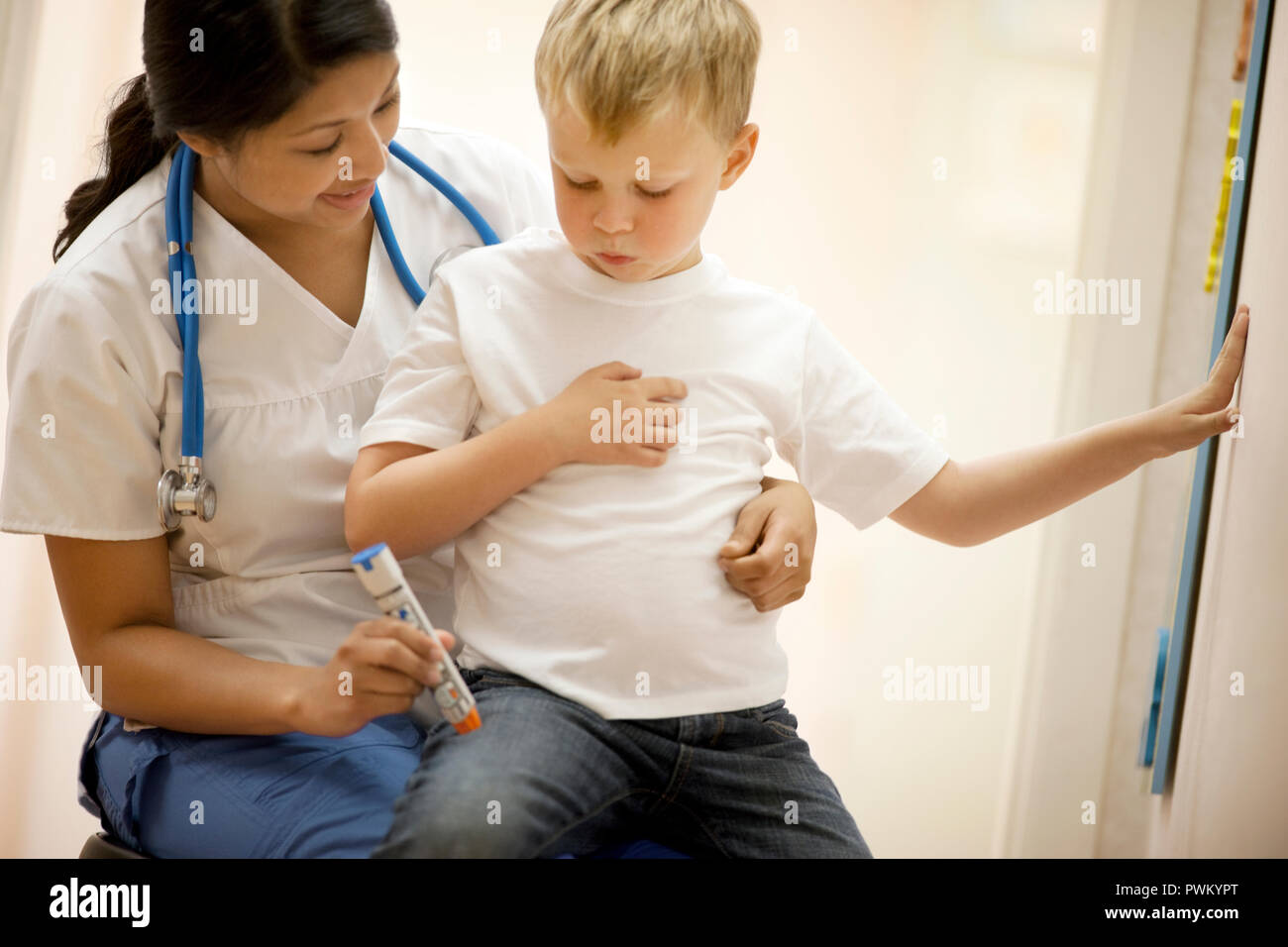 Boy sitting on nurses knee in hospital Stock Photo - Alamy