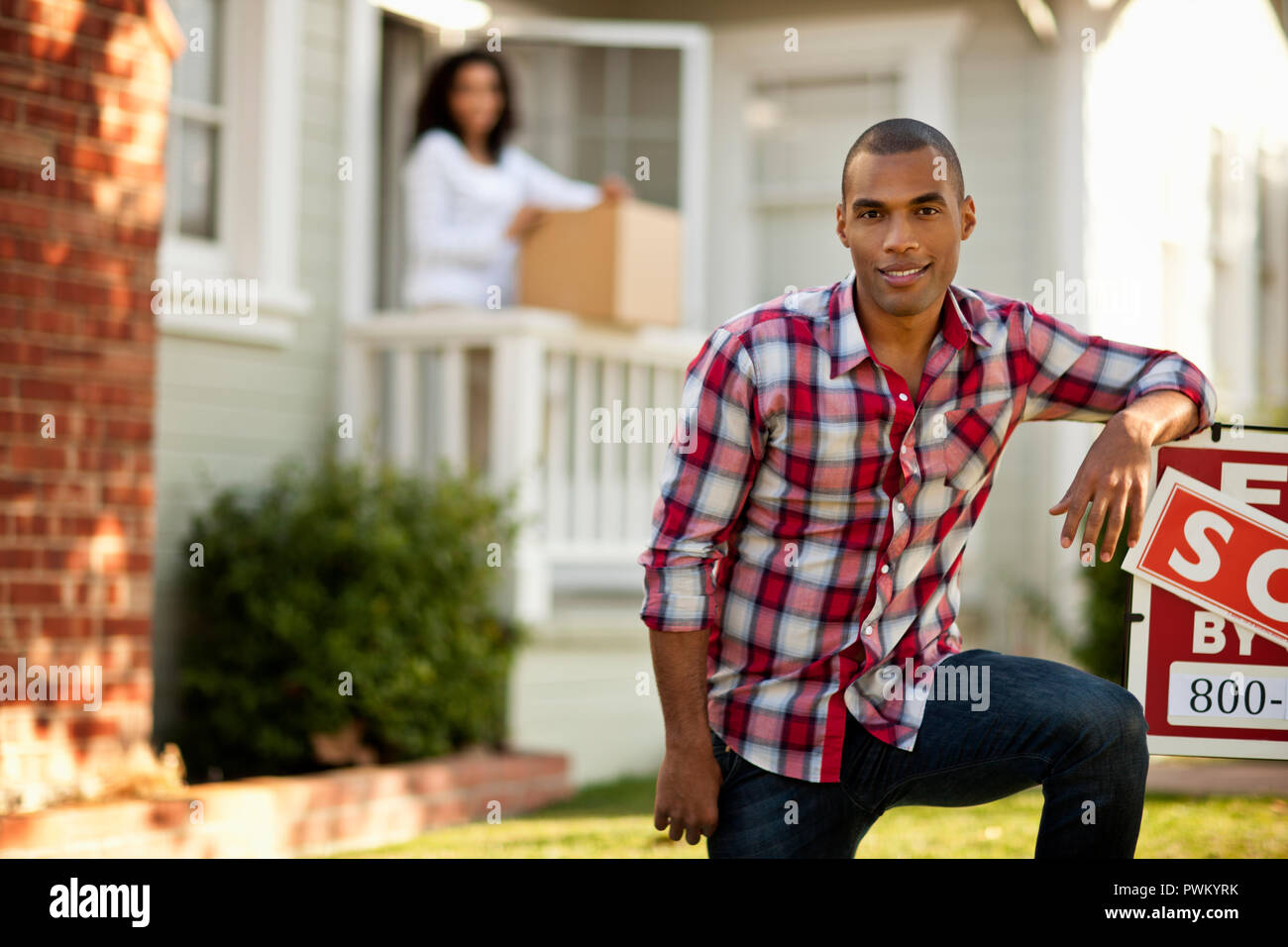 Portrait of mid-adult man standing outside their new home Stock Photo ...