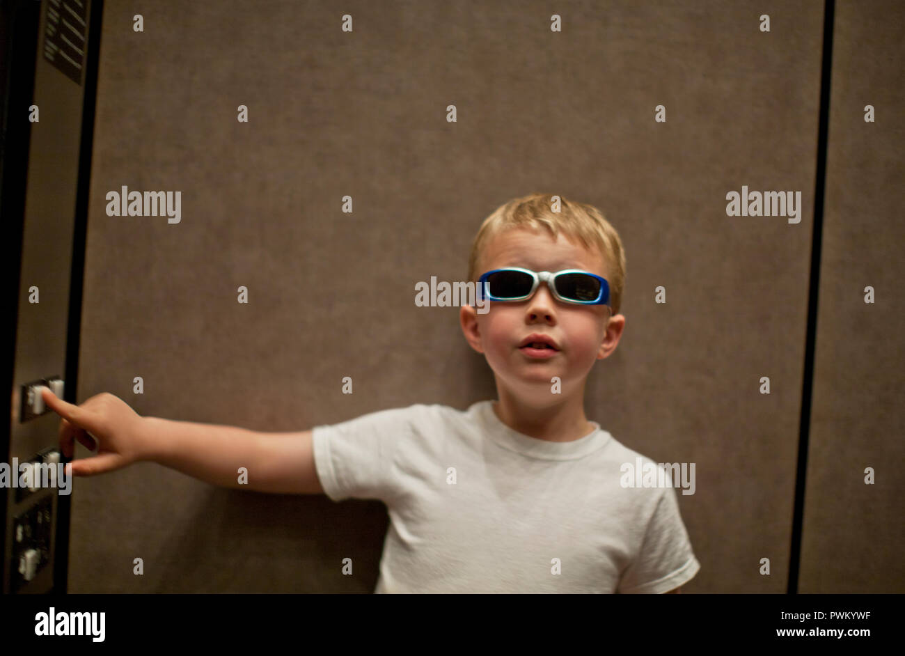 Young boy pressing a button in an elevator Stock Photo - Alamy