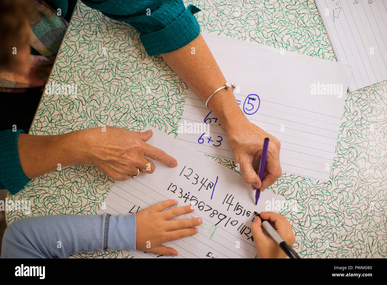 Mature woman helping a young boy with math Stock Photo - Alamy