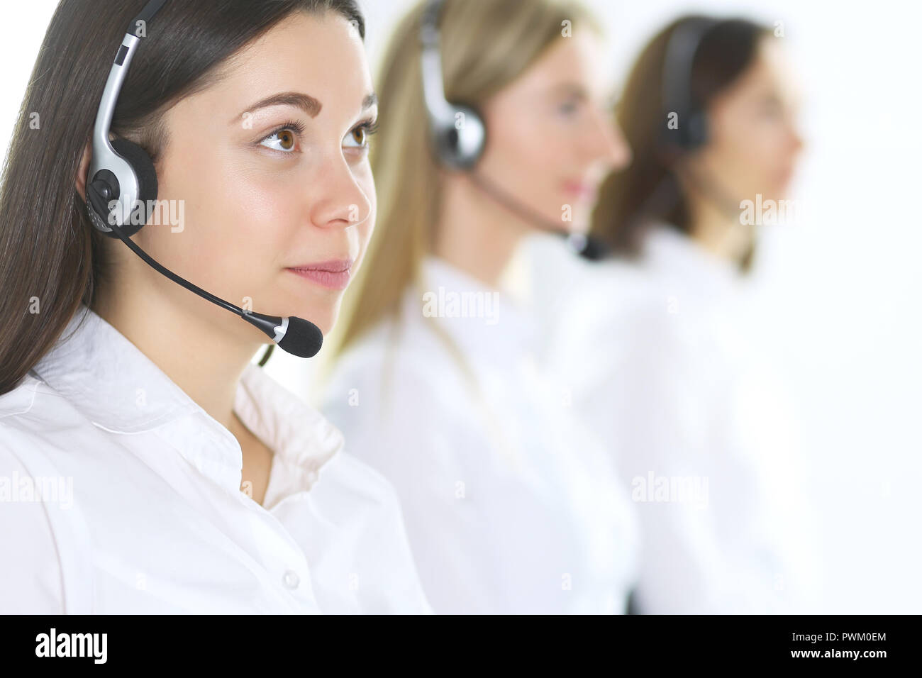 Group of call center operators at work. Focus at beautiful business woman in headset Stock Photo ...