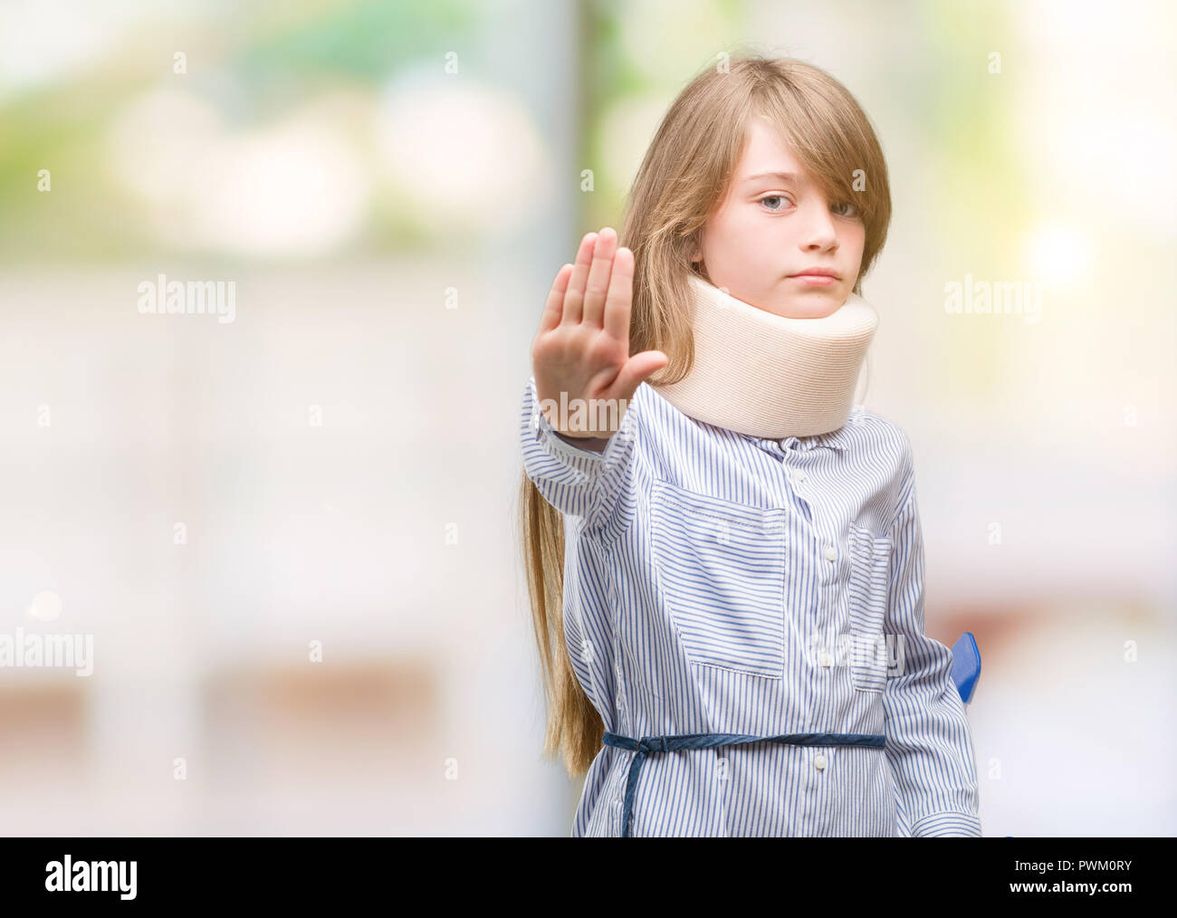 Young blonde child injured wearing neck collar and crutches with open ...