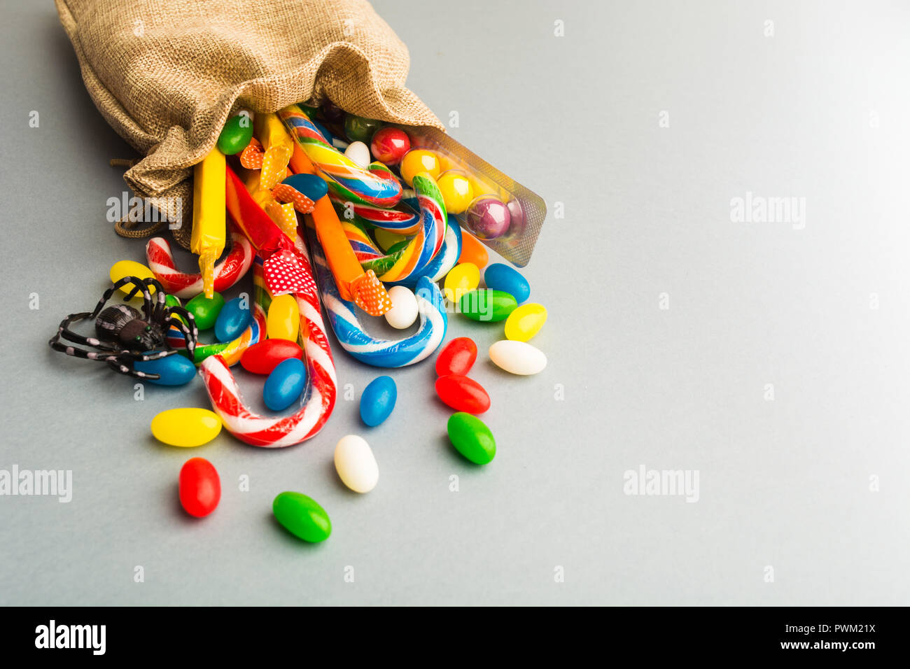 Various candies from material candies with halloween spider on grey ...