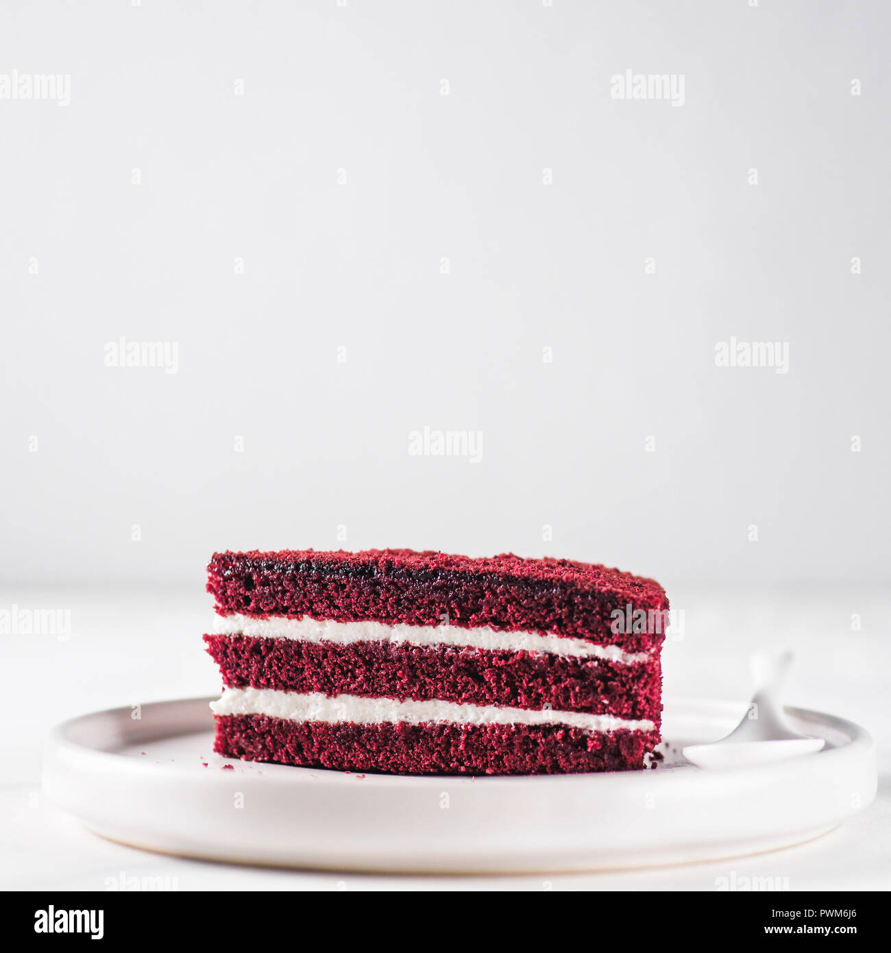 Piece of red velvet cake with perfect texture in matte plate on white ...