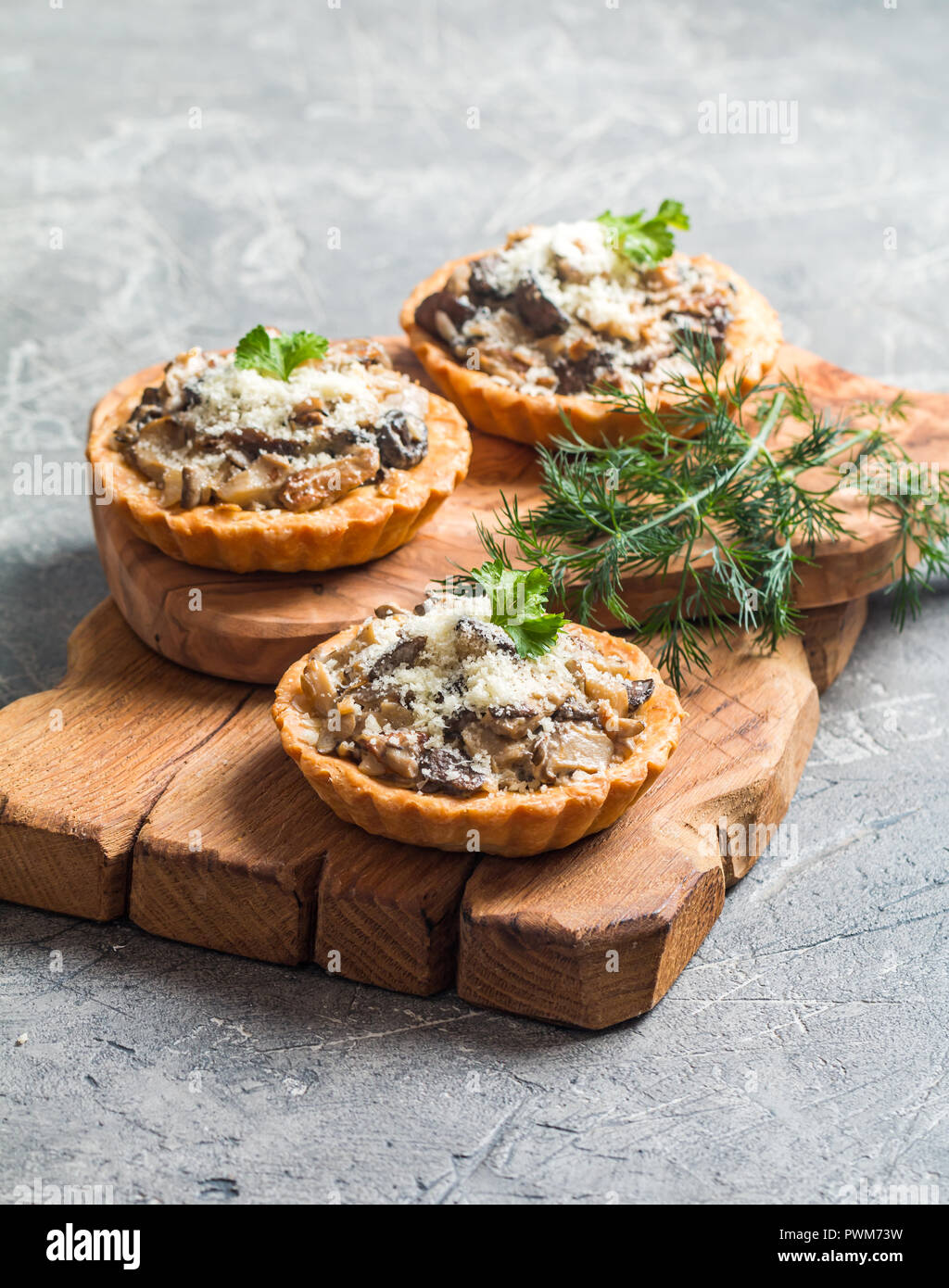 Homemade savory autumn tarts with fresh seasonal mushrooms in a crisp ...