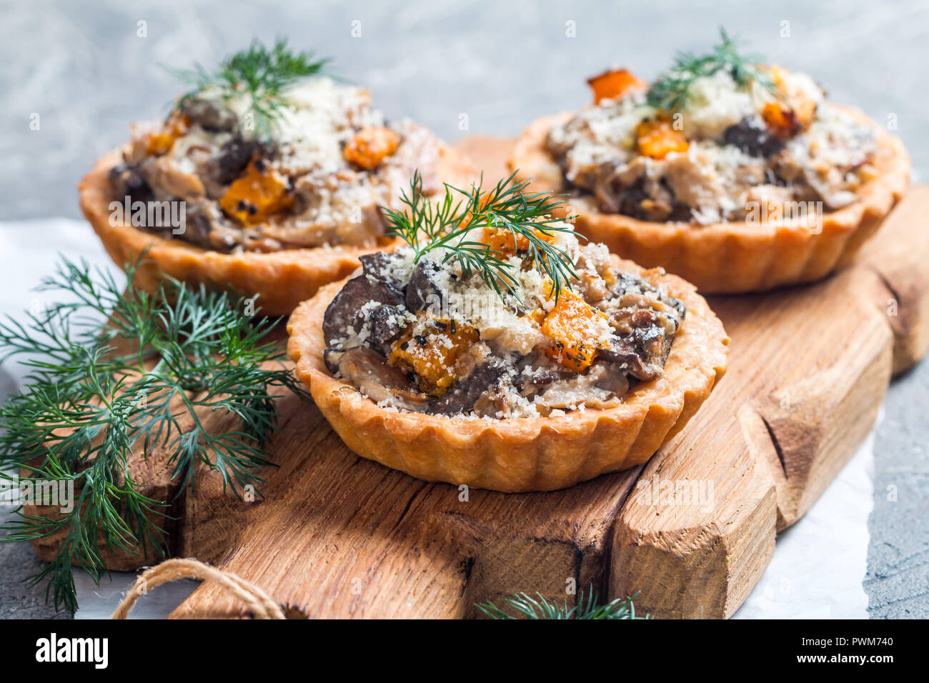 Homemade savory autumn tarts with fresh seasonal mushrooms in a crisp ...