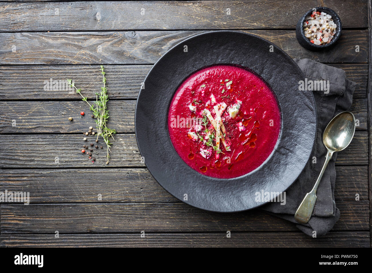 Cold Beetroot mashed soup with cream, apple, cheese and thyme in a dark ...