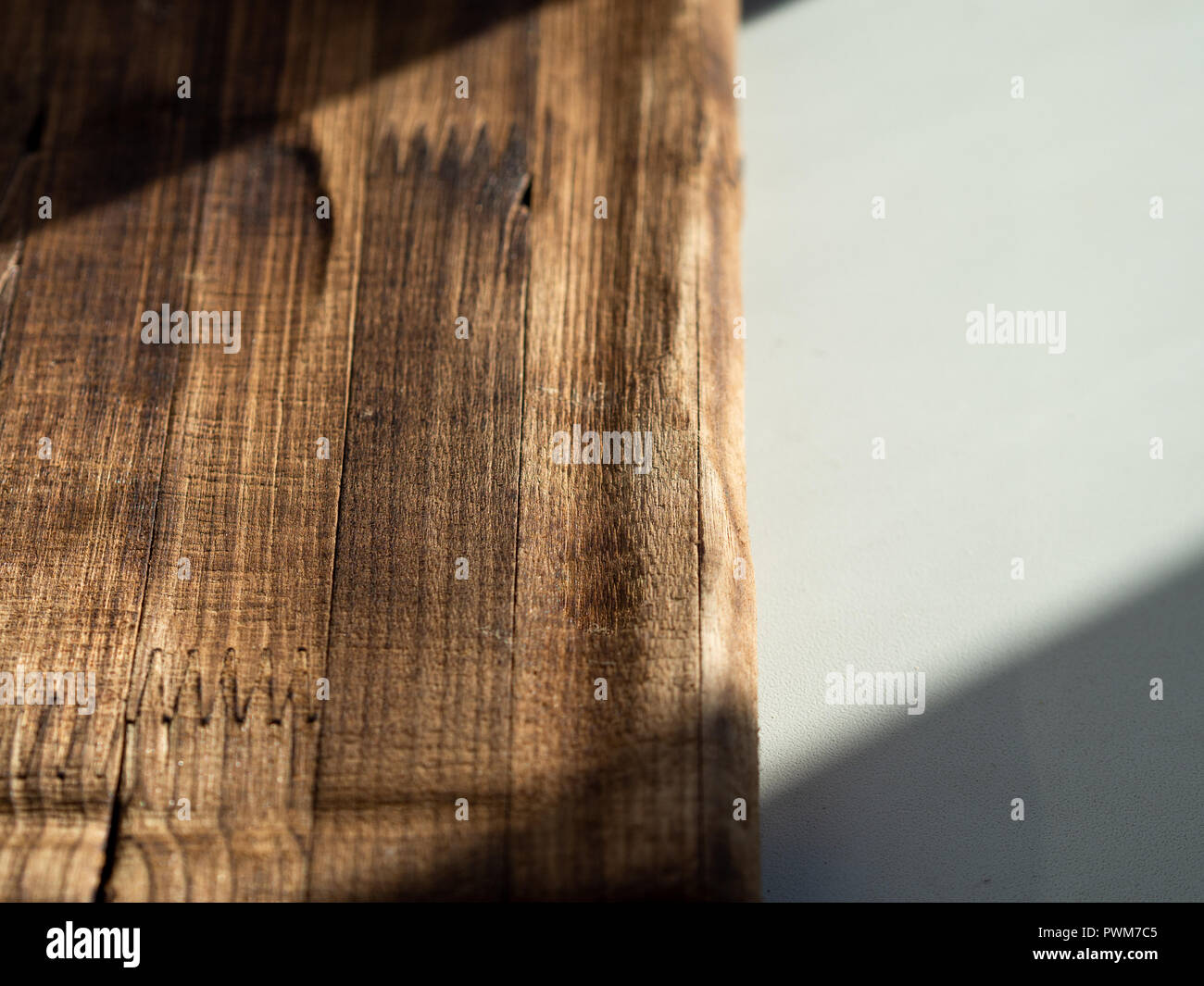 lines of sunlight and shadows on the surface; wooden texture and white ...