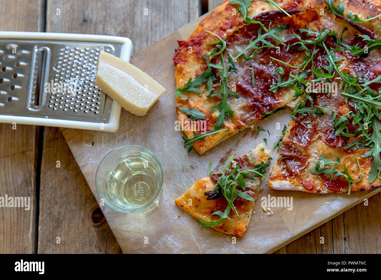 A ham and rocket pizza, sliced Stock Photo - Alamy