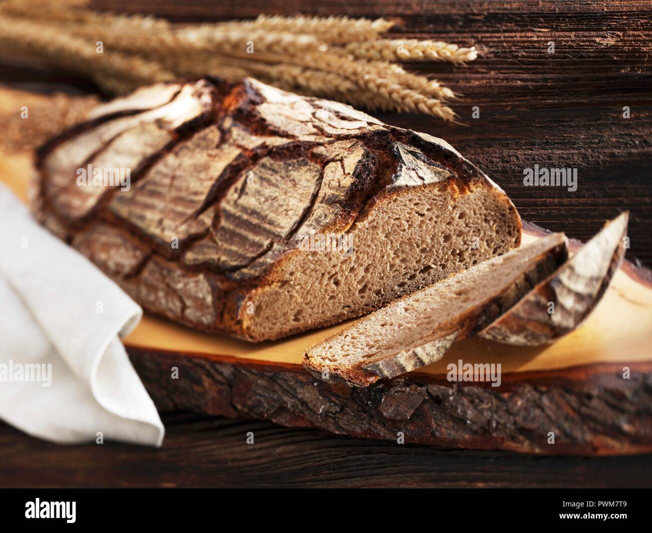 A rustic country loaf on a slice of wood Stock Photo - Alamy
