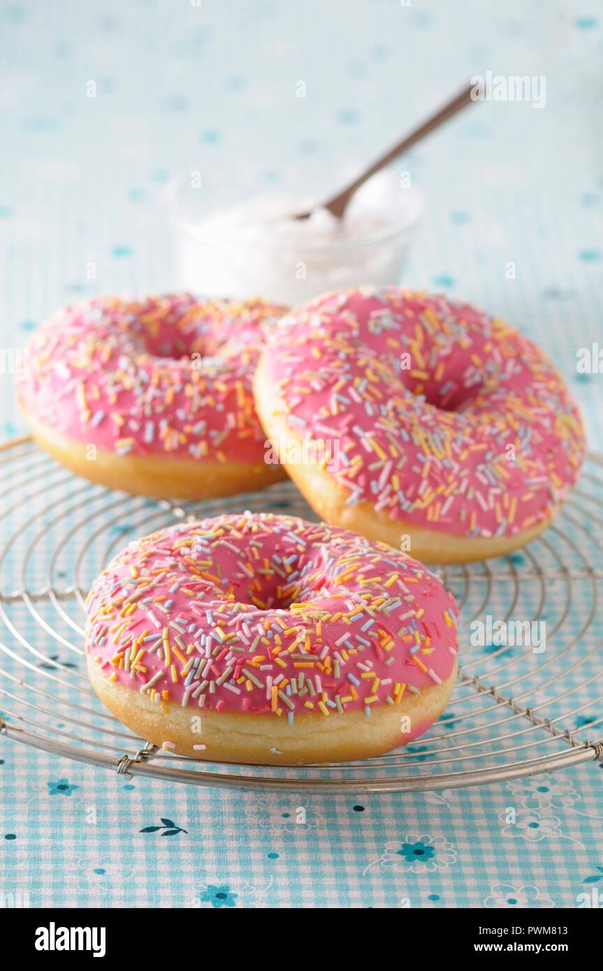 Pink glazed doughnuts with sugar sprinkles Stock Photo - Alamy