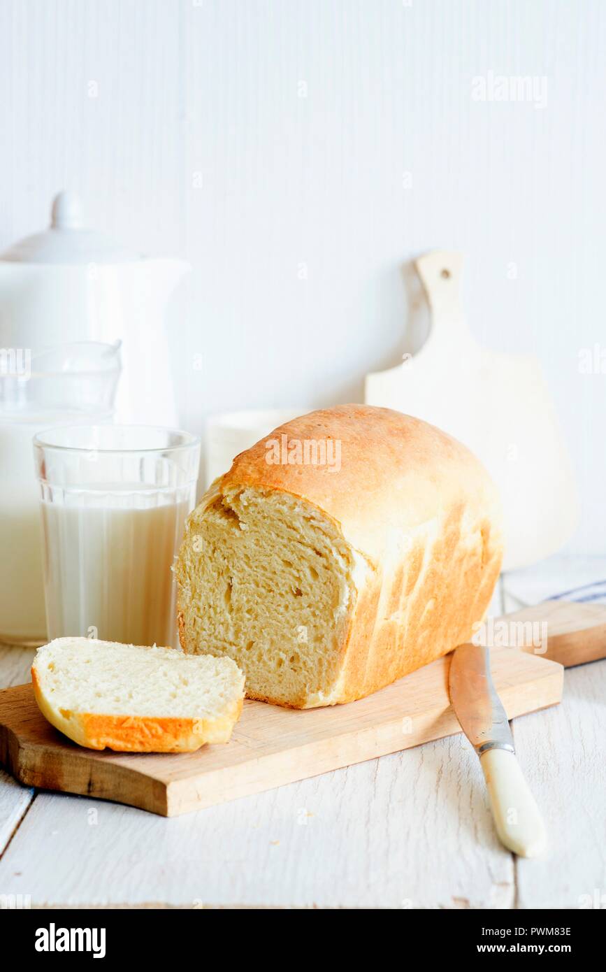 A sliced loaf od home-made milk bread on a chopping board Stock Photo ...