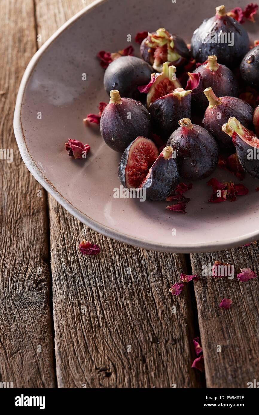 Fresh baby figs in rustic bowl on rustic table with rose petals Stock ...