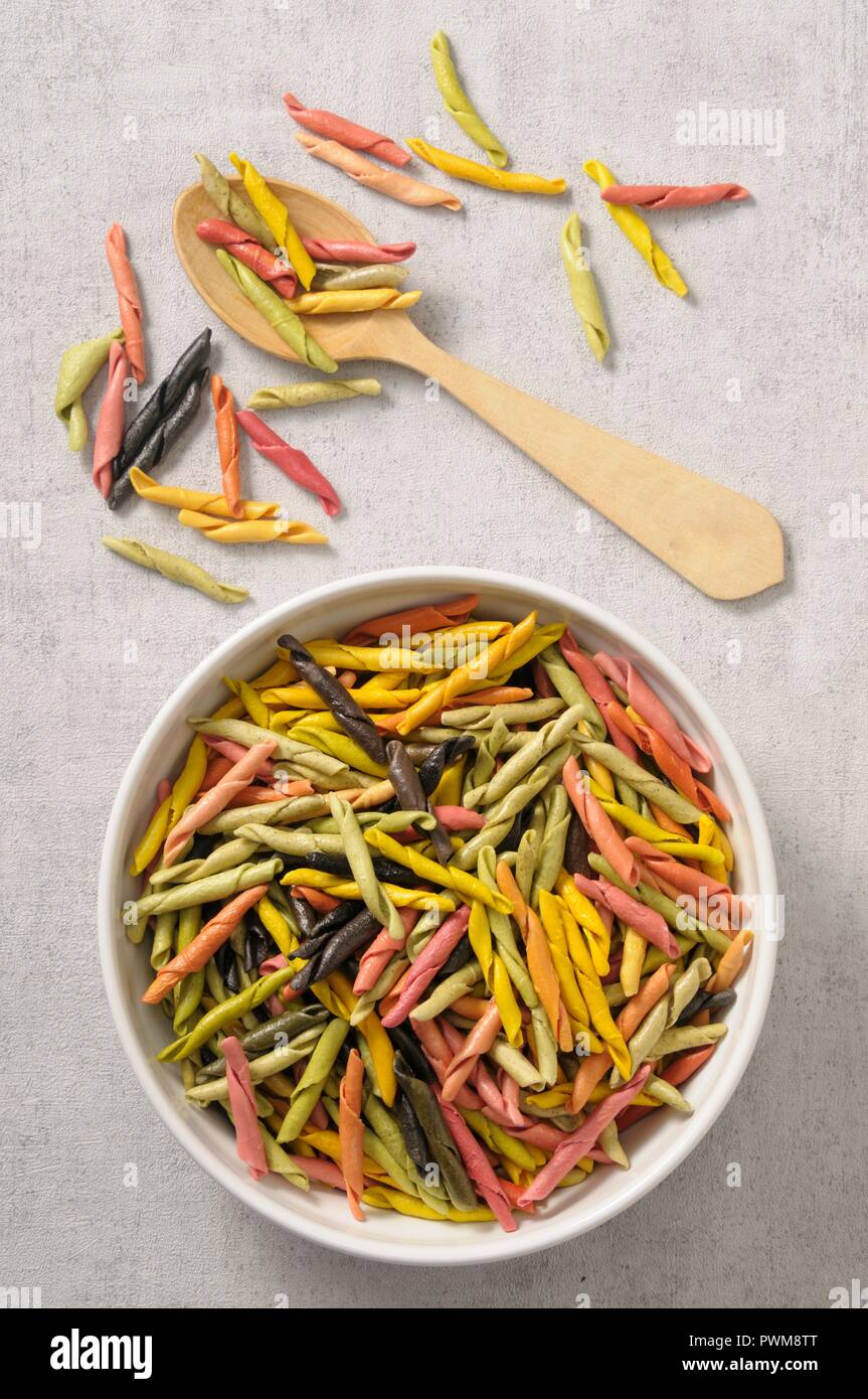 Colourful pasta in a bowl and next to it (seen from above Stock Photo ...