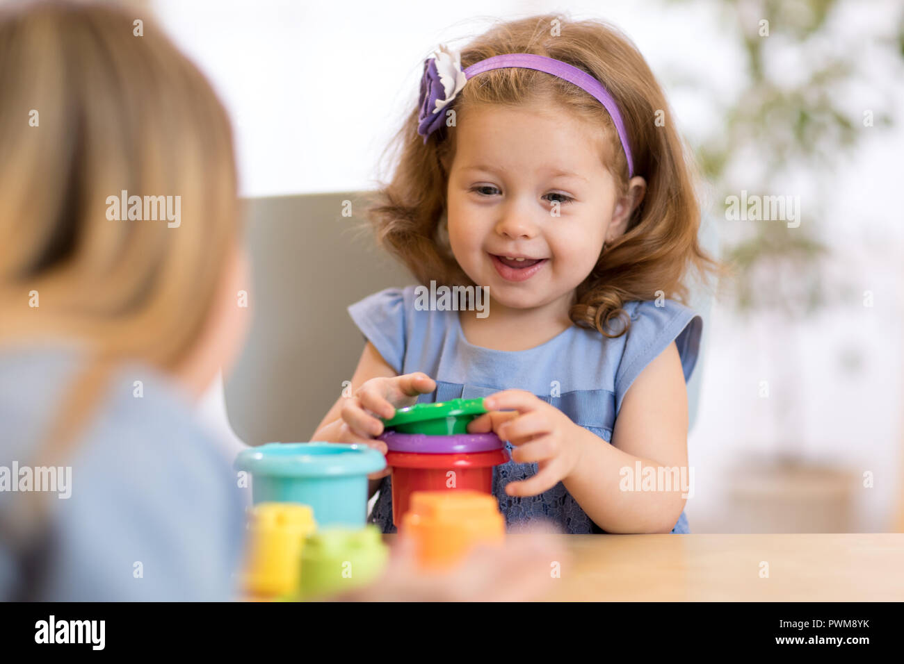 Child girl playing stacking cups at home Stock Photo - Alamy
