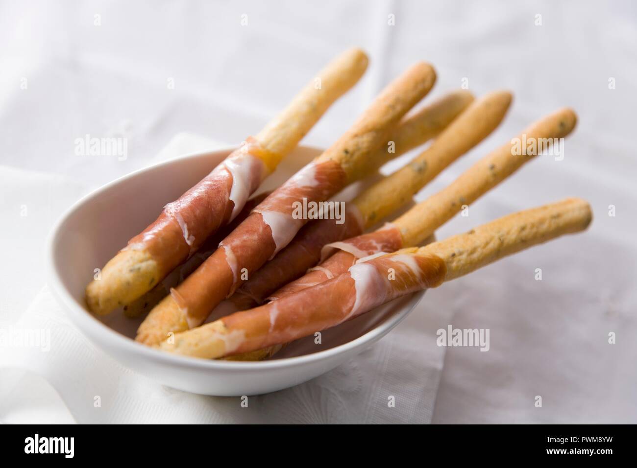 Grissini wrapped in ham Stock Photo - Alamy