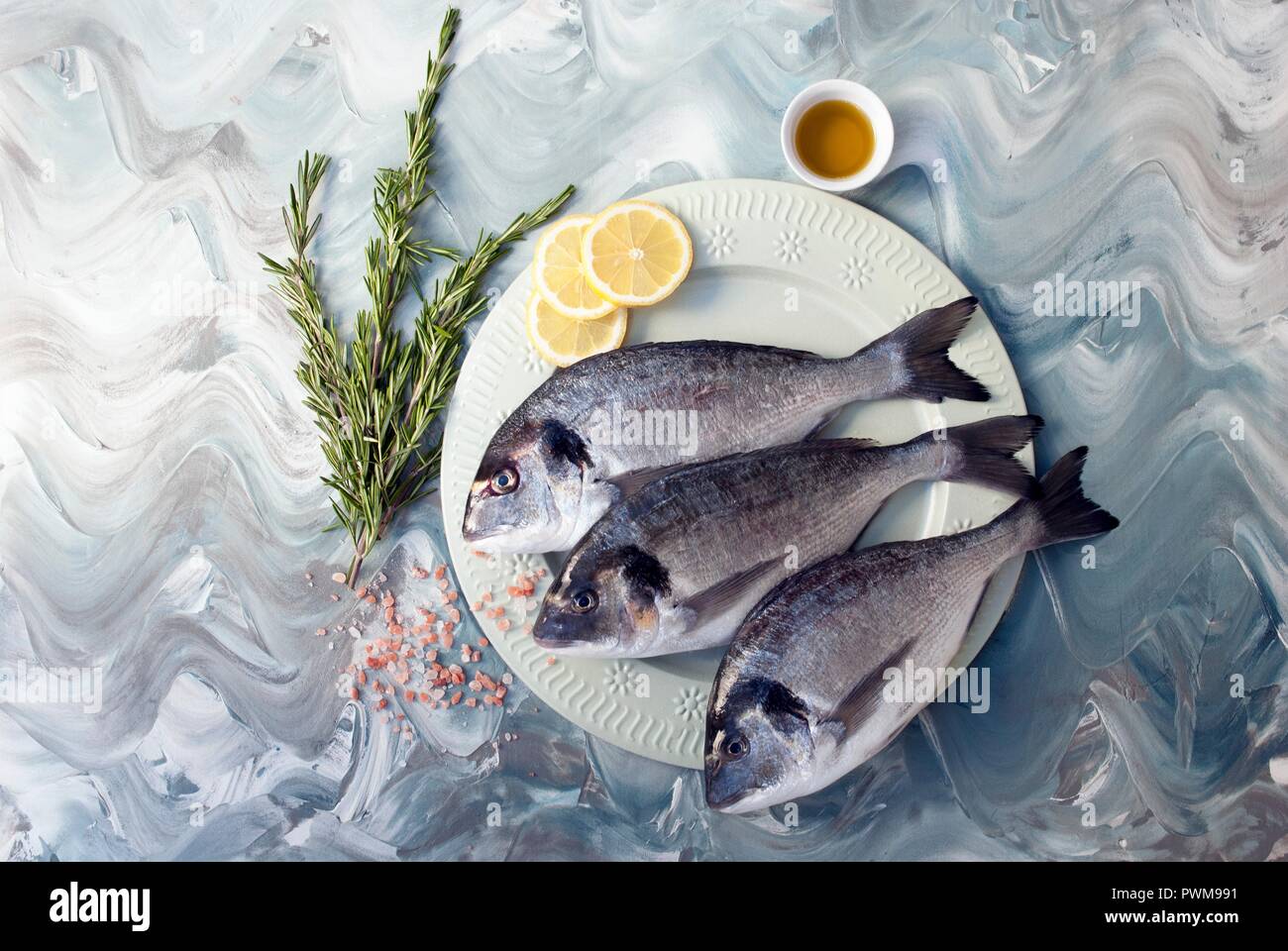 Fresh breams, lemons, salt and rosemary Stock Photo - Alamy