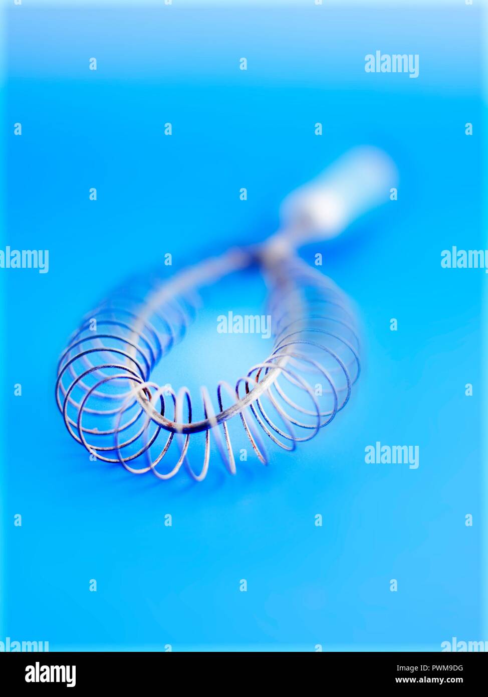 A whisk on a blue background Stock Photo - Alamy