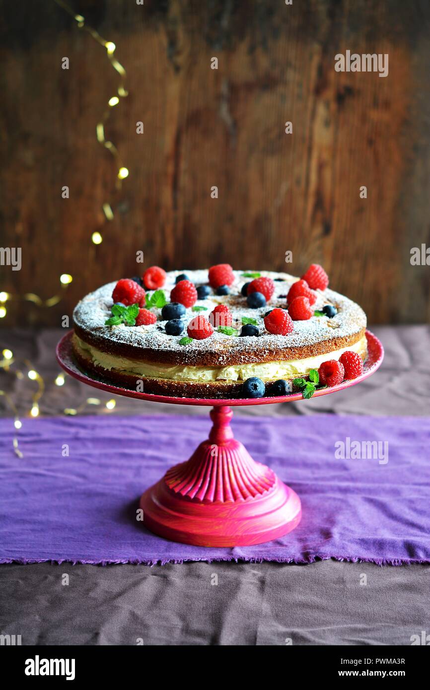 Biscuit cake with forest fruits and cream on a stand Stock Photo - Alamy