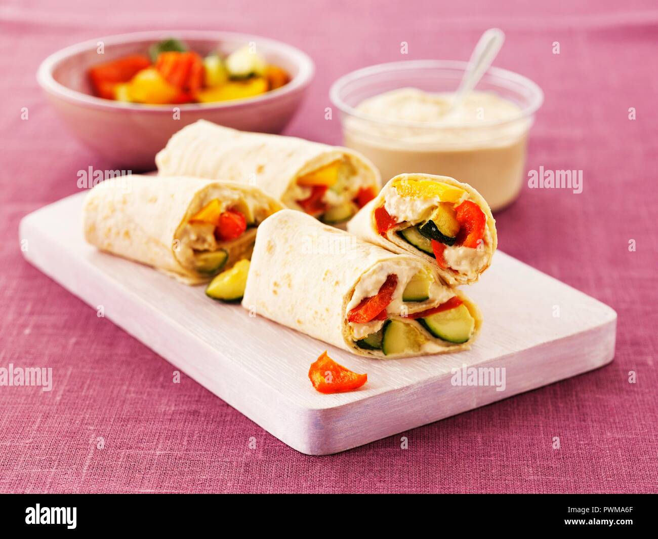 Wraps with hummus, cucumber and peppers on a board Stock Photo - Alamy