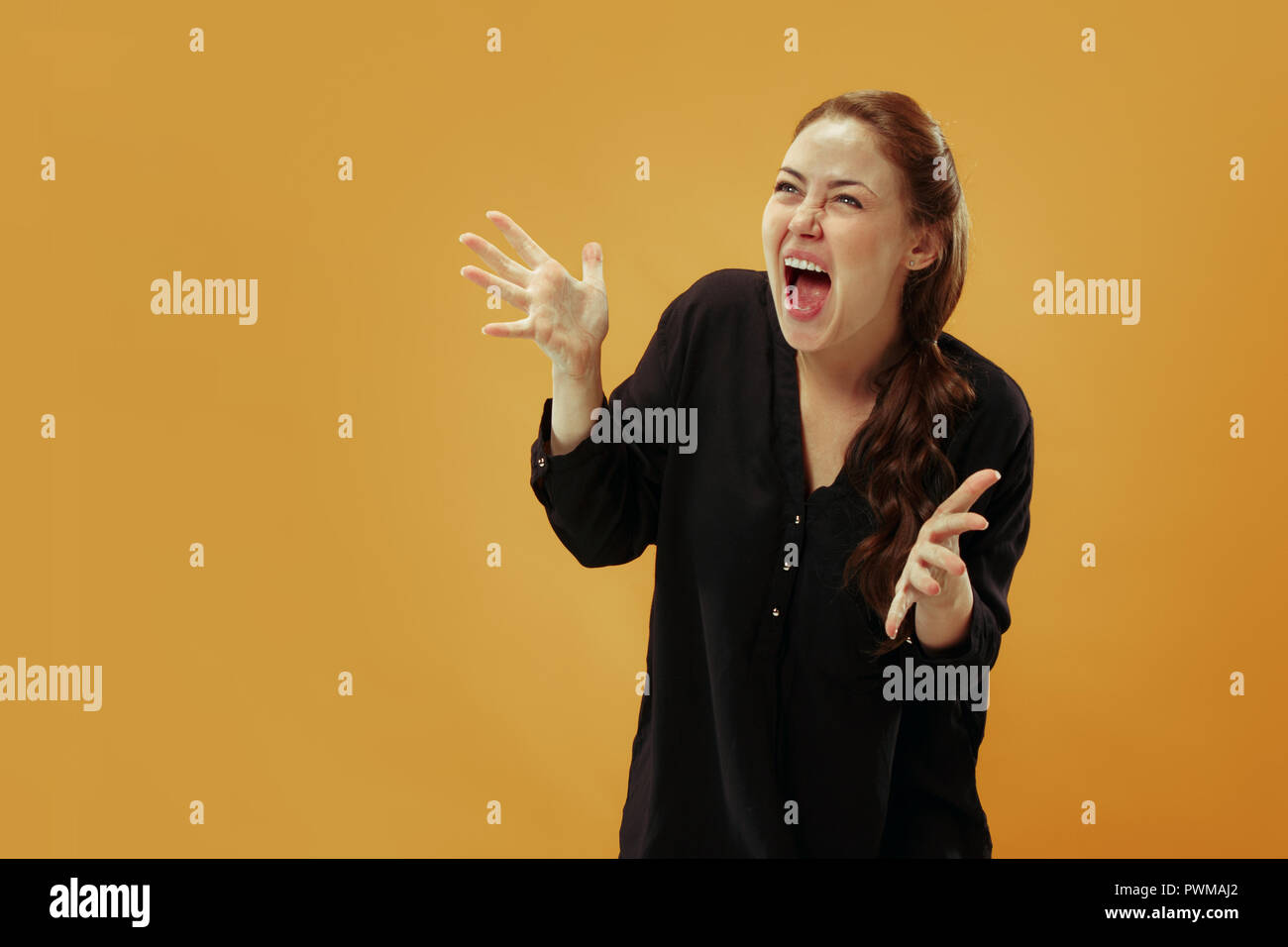 Screaming, hate, rage. Crying emotional angry woman screaming on gold ...