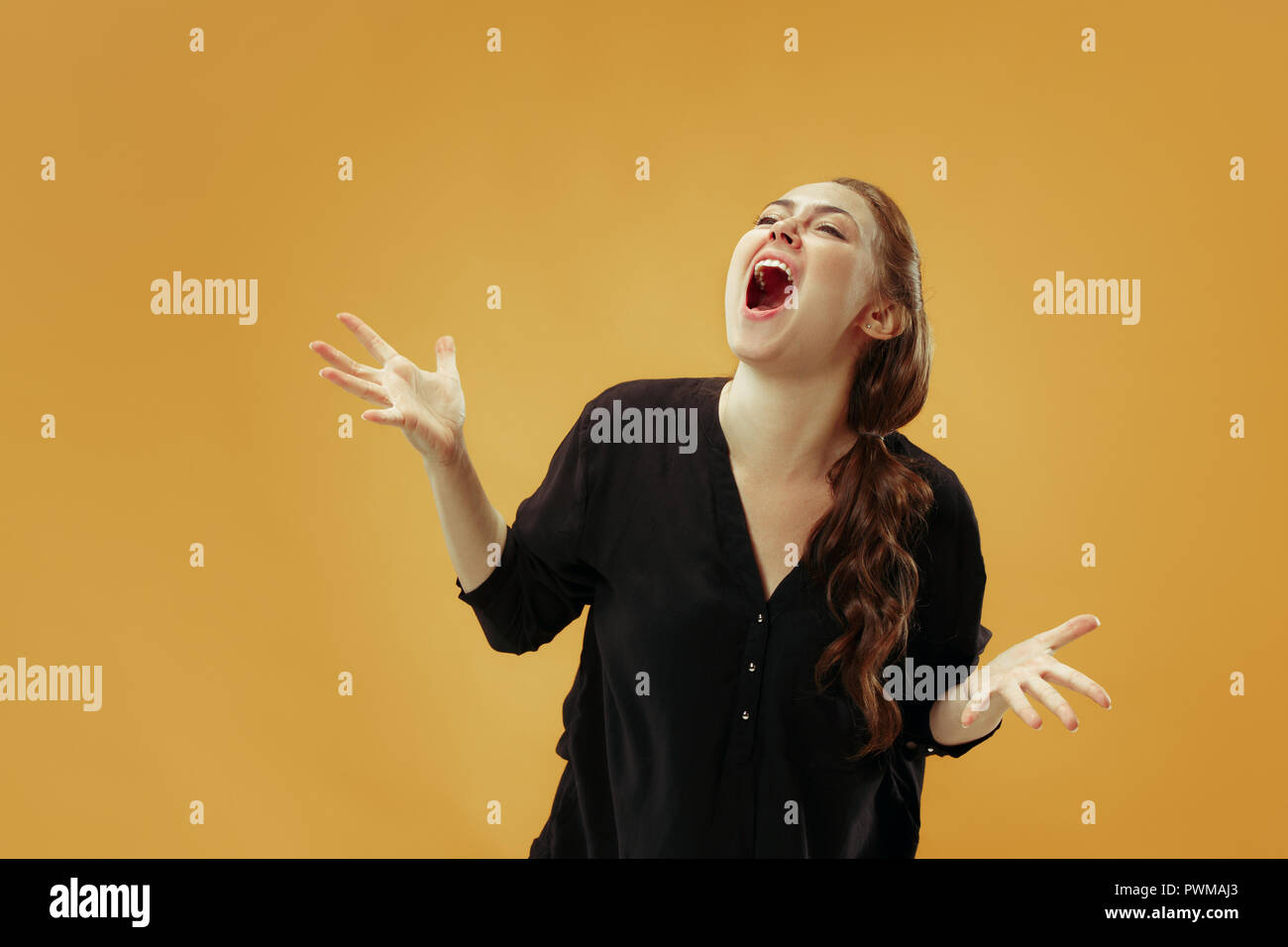Screaming, hate, rage. Crying emotional angry woman screaming on gold ...