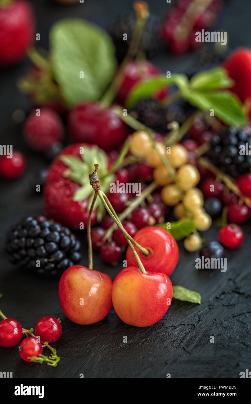 Mixed berries on a dark background with selected focus. Strawberries ...