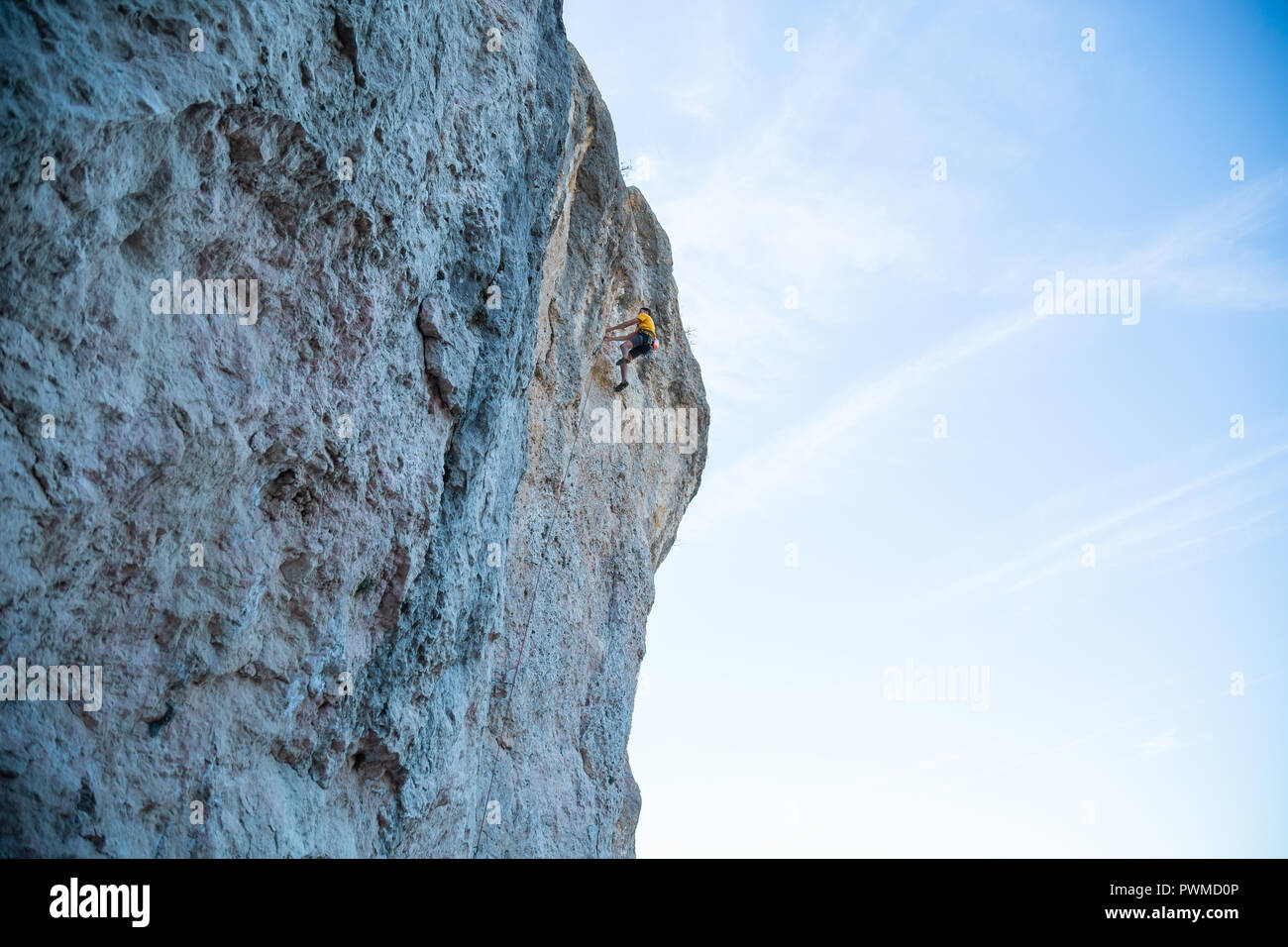 View of man without helmet hanging on a rope while rappelling and shows ...