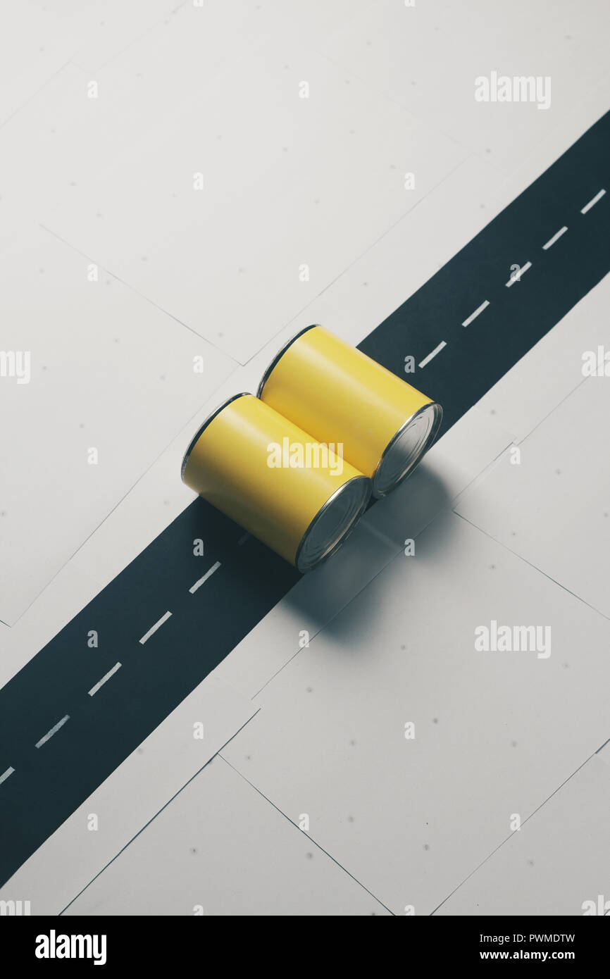 Two yellow tin cans on a road Stock Photo - Alamy