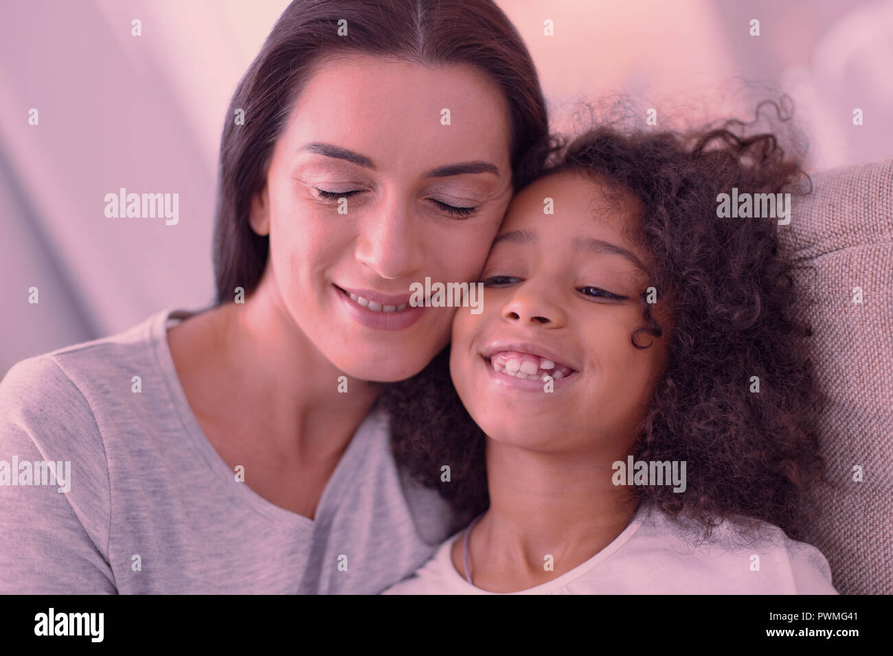 Delighted nice young woman closing her eyes Stock Photo - Alamy
