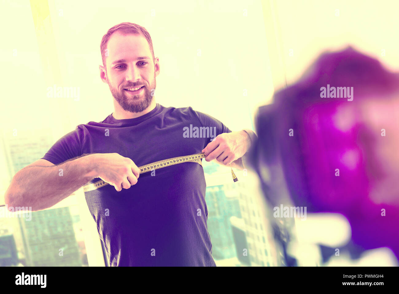 Handsome attractive man measuring his muscles in front of the camera ...