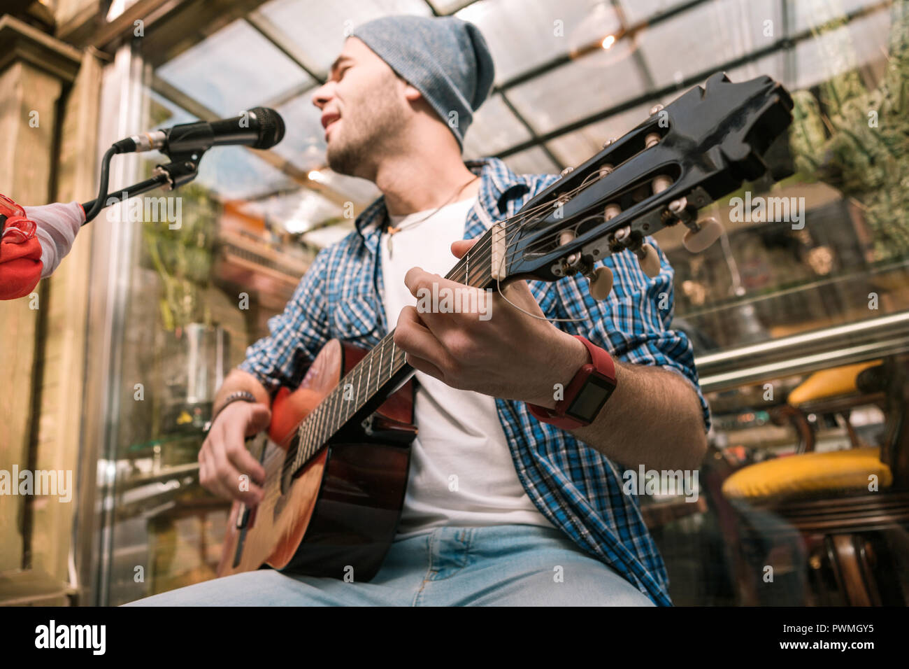 Inspired male guitarist singing song in bar Stock Photo - Alamy