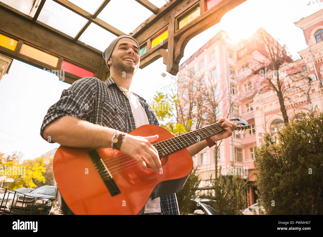 Inspired male guitarist making people happy with music Stock Photo - Alamy