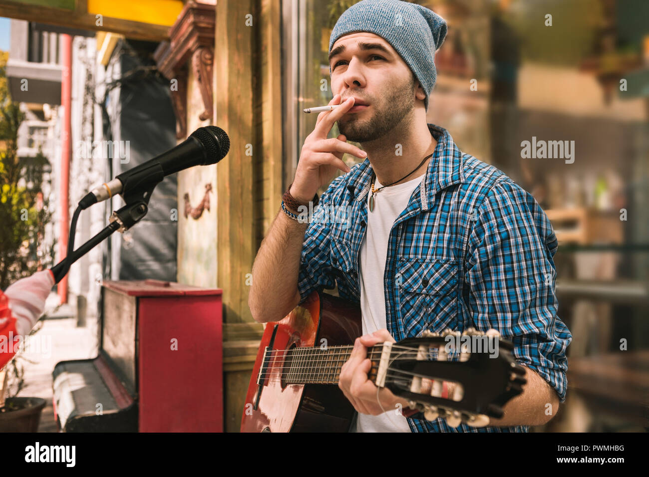 Pensive male guitarist smoldering cigarette on street Stock Photo - Alamy