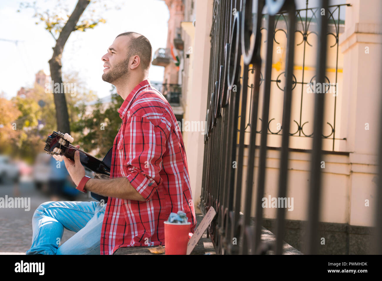 Inspired street musician giving performance on street Stock Photo - Alamy