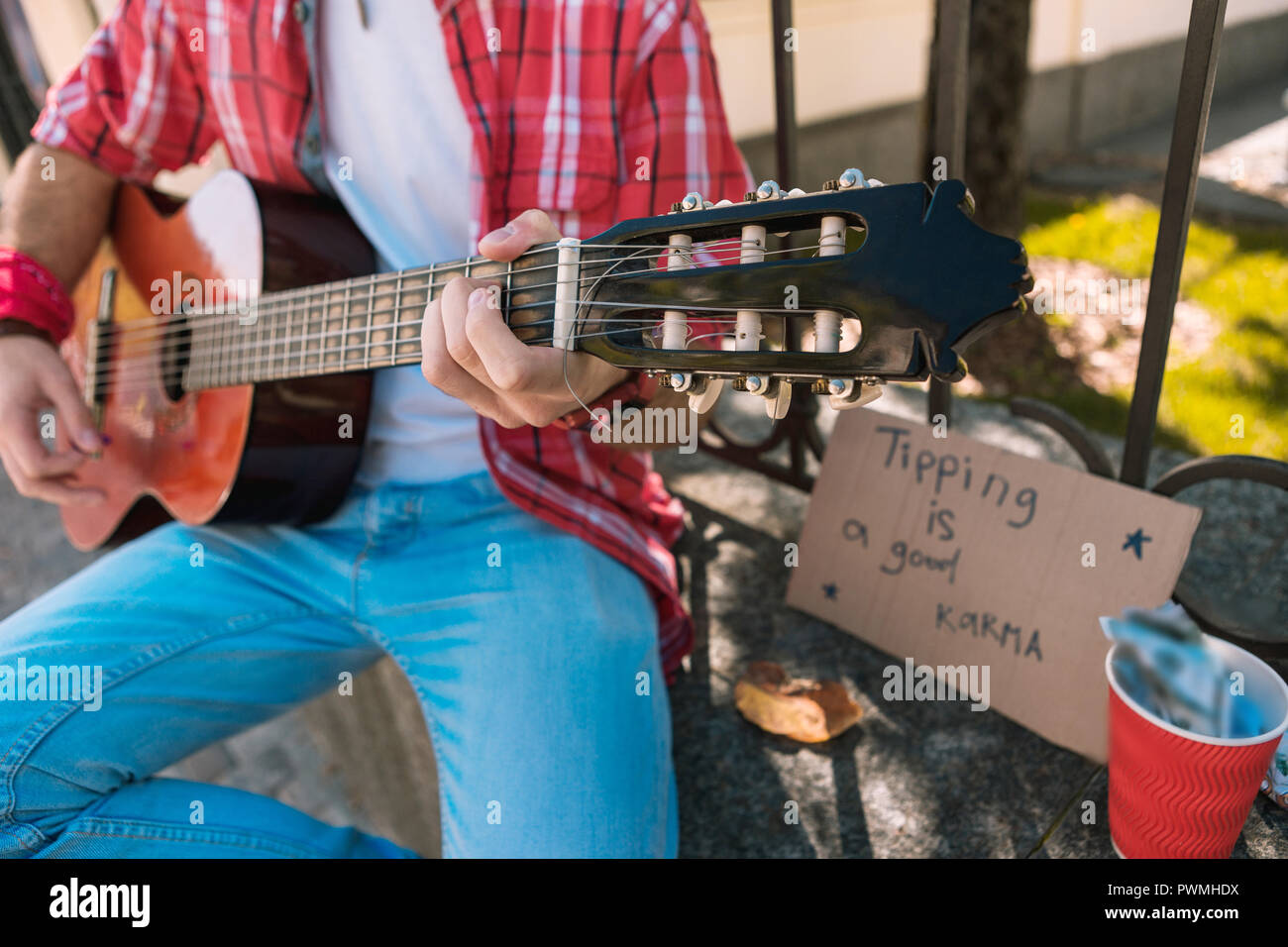 Active street musician changing music with guitar Stock Photo - Alamy