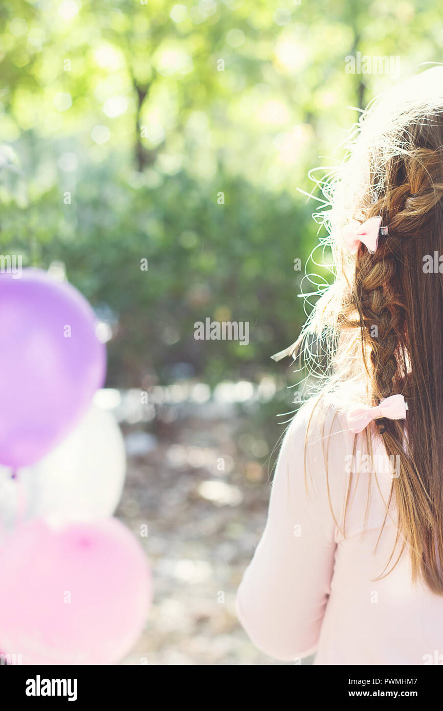 Little girl with braided hair holds her balloons, in the park Stock ...