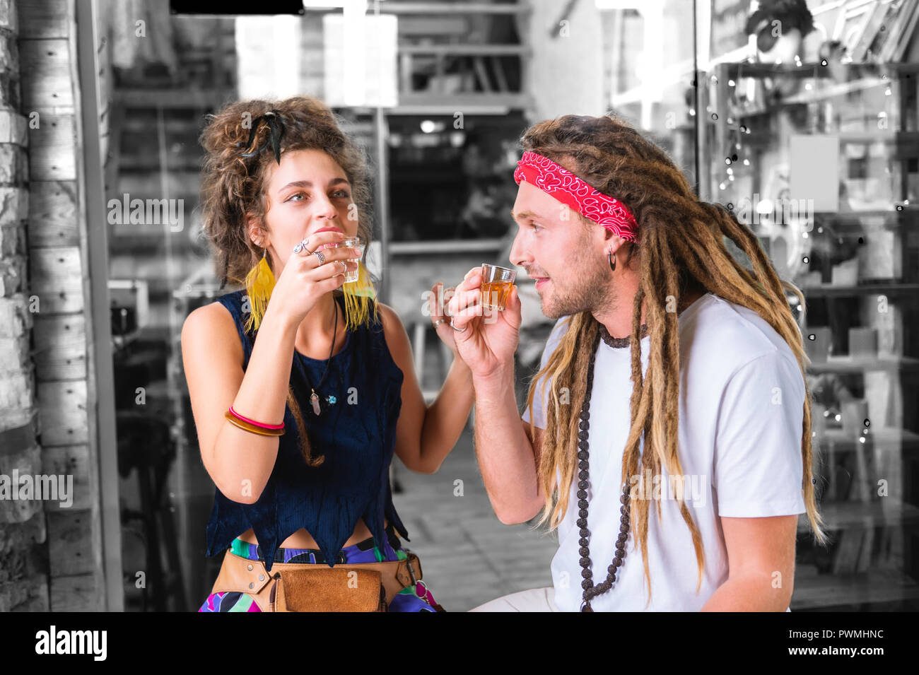 Boyfriend and girlfriend wearing bright clothes chilling drinking ...