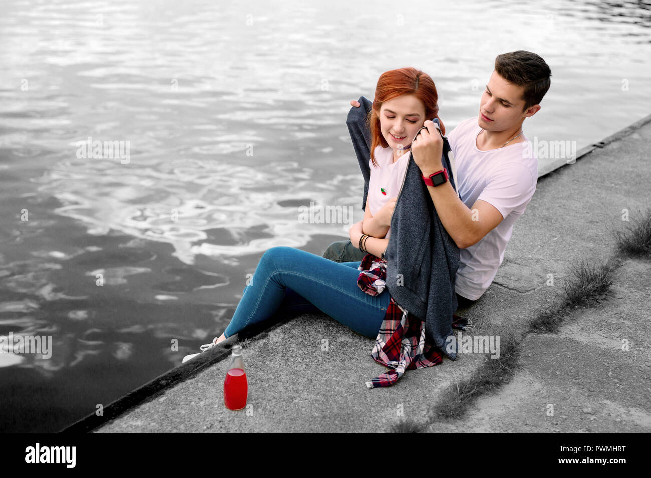 Caring loving boyfriend giving his sport jacket his girlfriend on cold ...