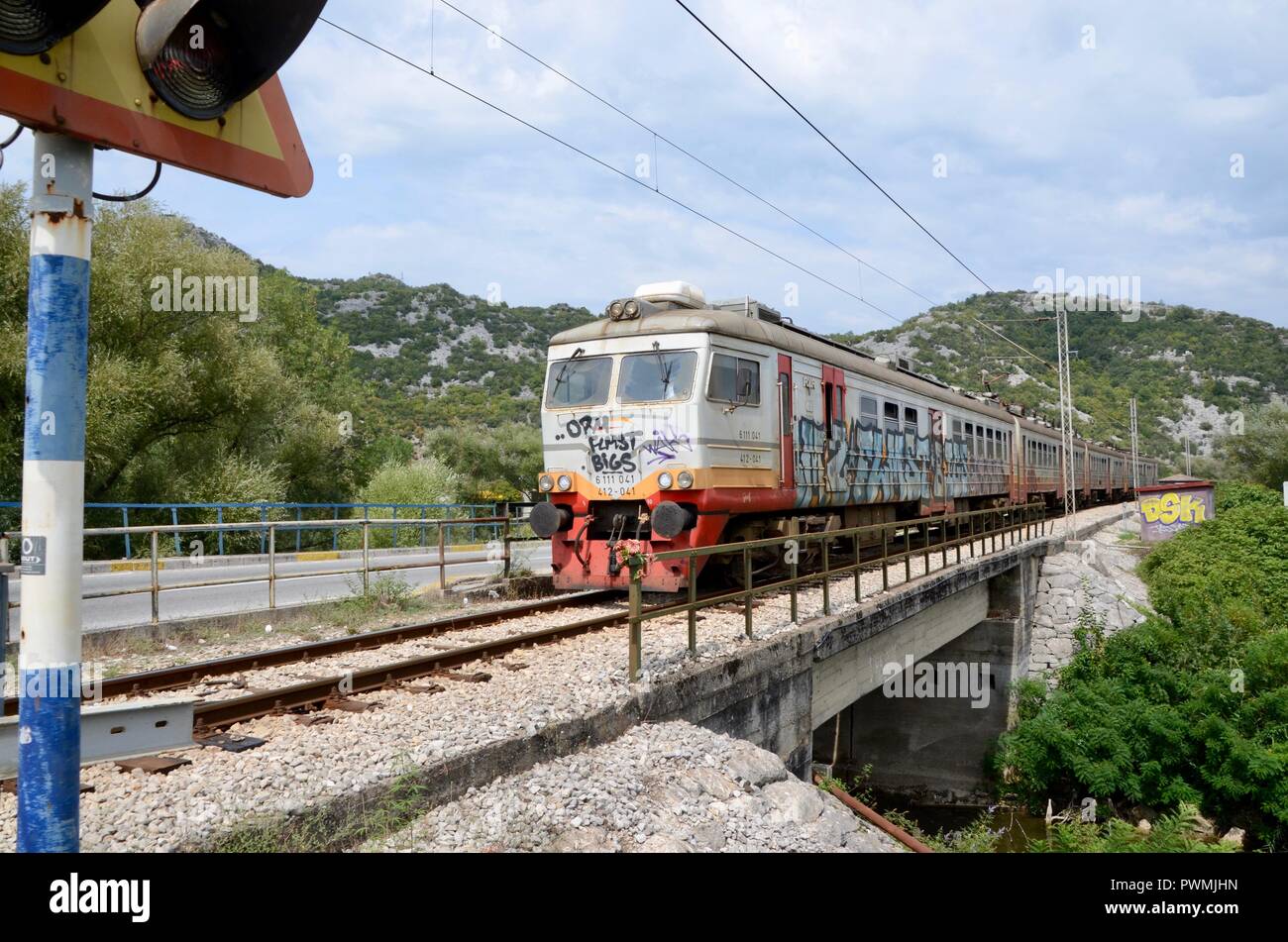 passenger train covered in graffiti passes lake skadar in montenegro ...