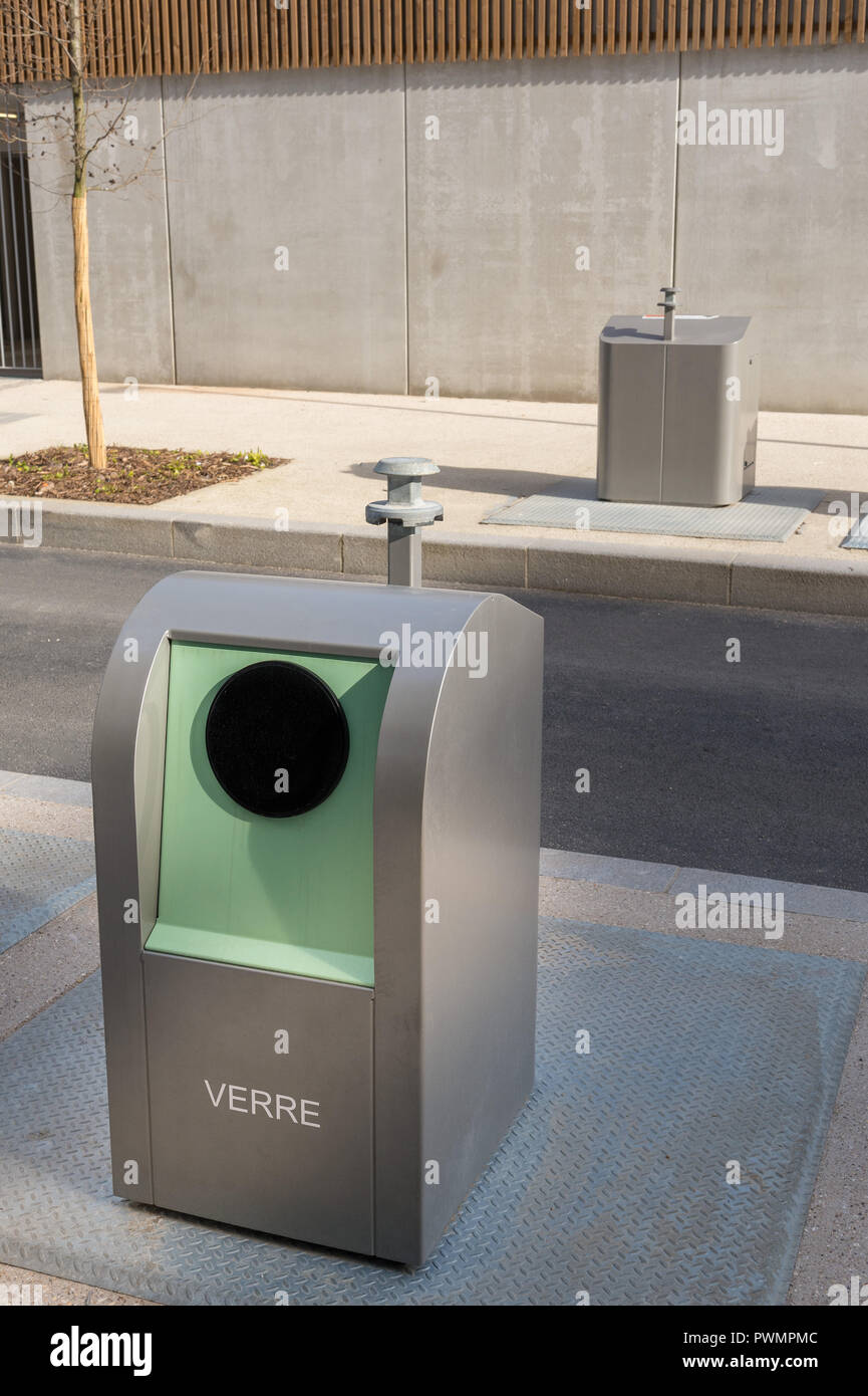Sorting out garbage containers burried in the street Stock Photo - Alamy