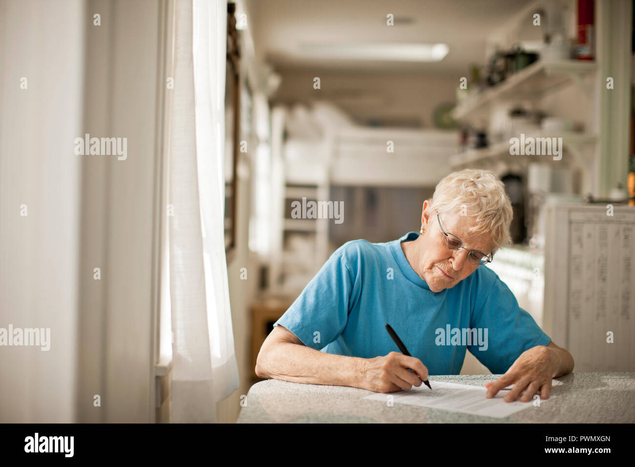 Senior woman writes kitchen table hi-res stock photography and images ...