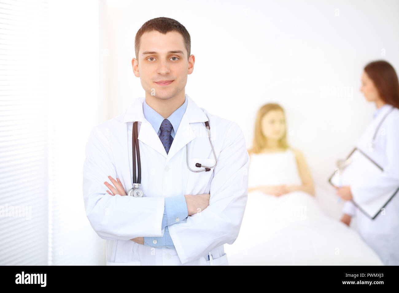Medicine doctor standing and smiling on the background with patient in ...