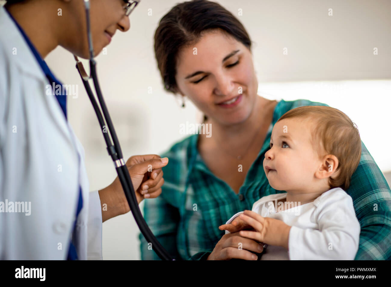 Mid adult doctor holding baby boy hi-res stock photography and images ...