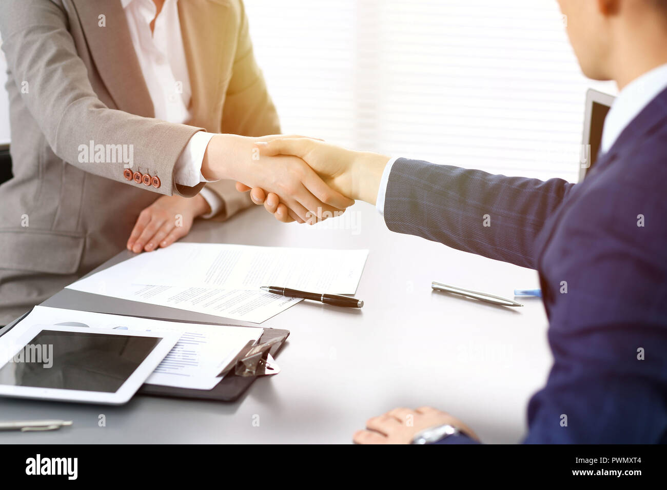 Business people shaking hands, finishing up a meeting. Papers signing ...
