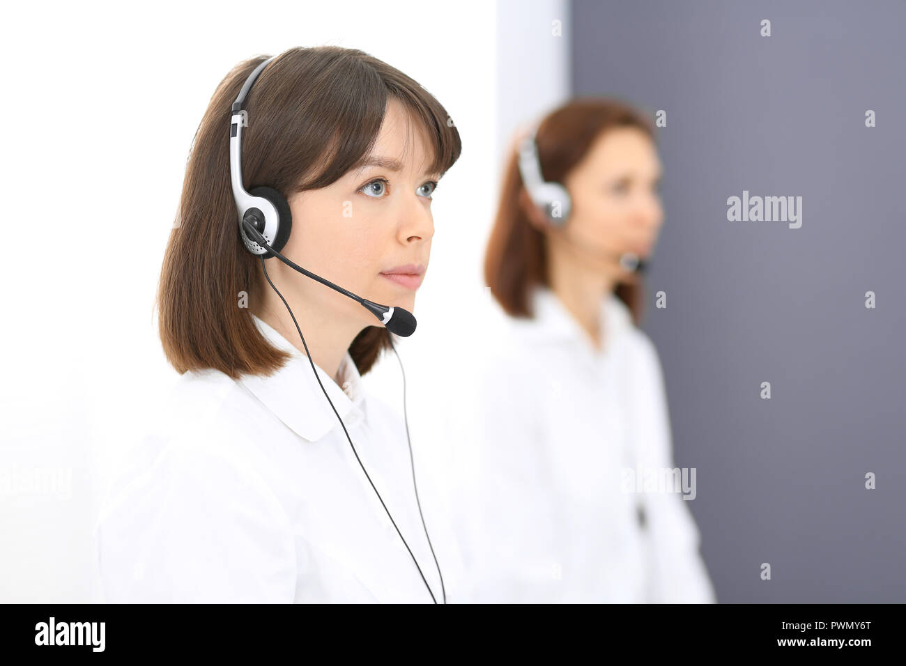 Call center. Group of operators at work. Focus on young brunette woman. Business concept Stock ...