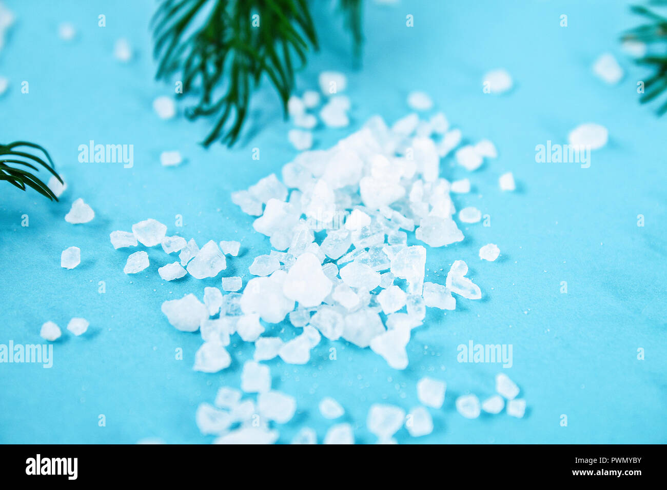 Crystals of large sea salt and dill on a blue table. Background for ...