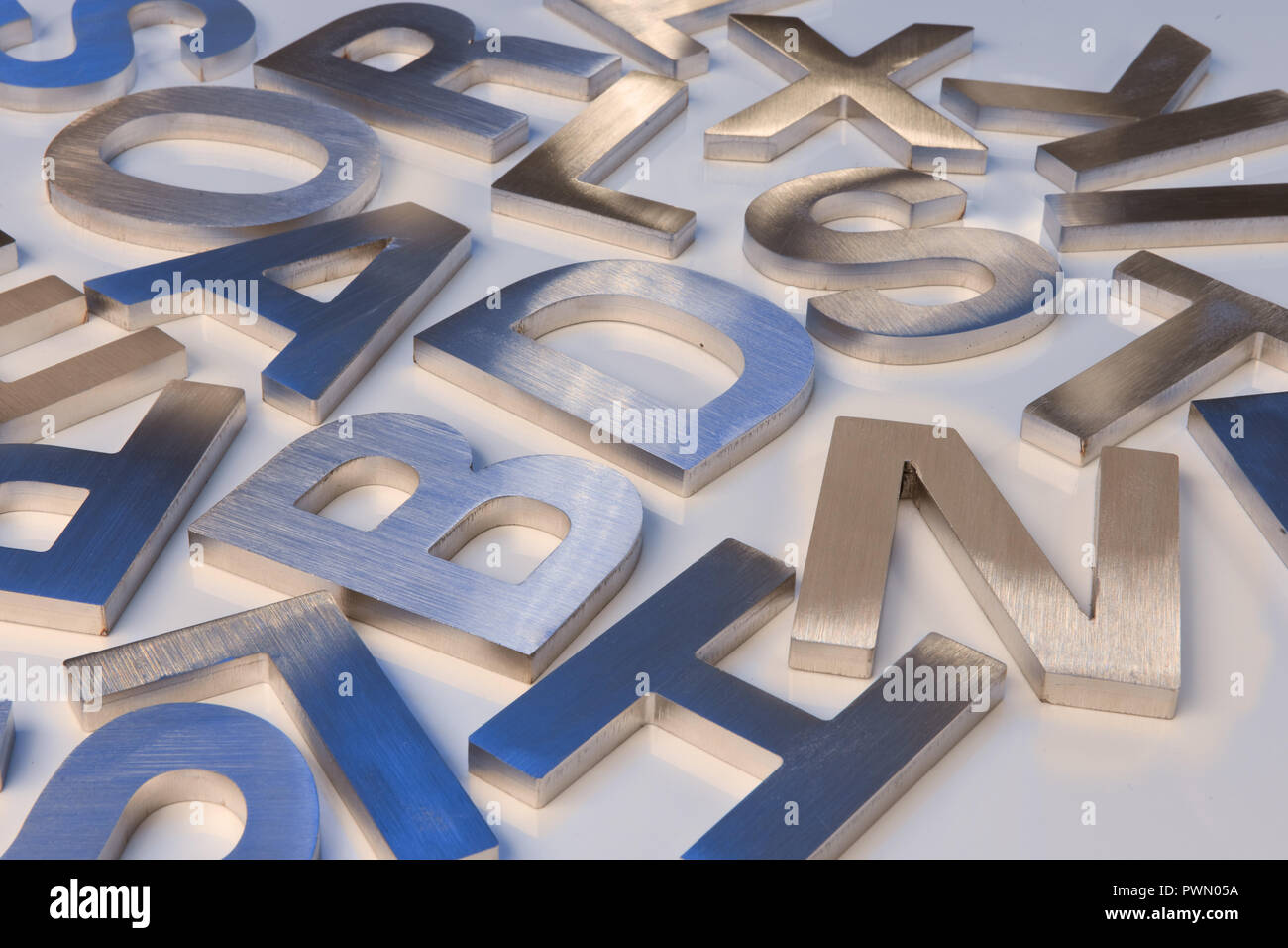 Shiny letters milled from metal lying on table Stock Photo - Alamy